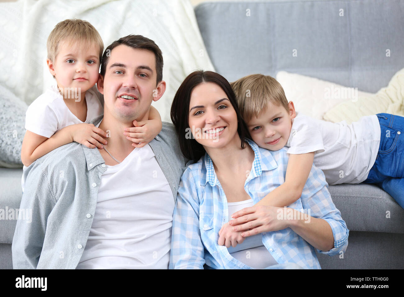 Happy family sitting on floor on couch background, closeup Stock Photo ...