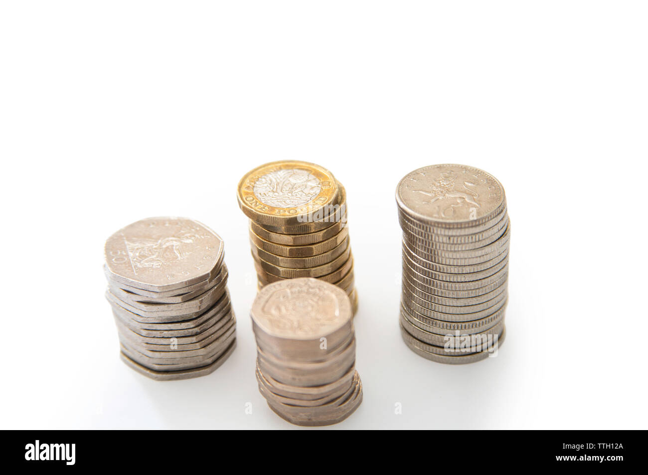 4 stacks of British coins on a white background Stock Photo - Alamy