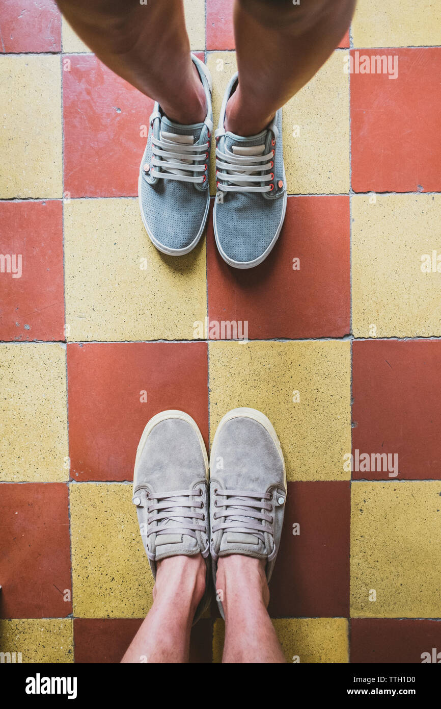 High angle view of women and men's feet on colorful tiled floor Stock ...