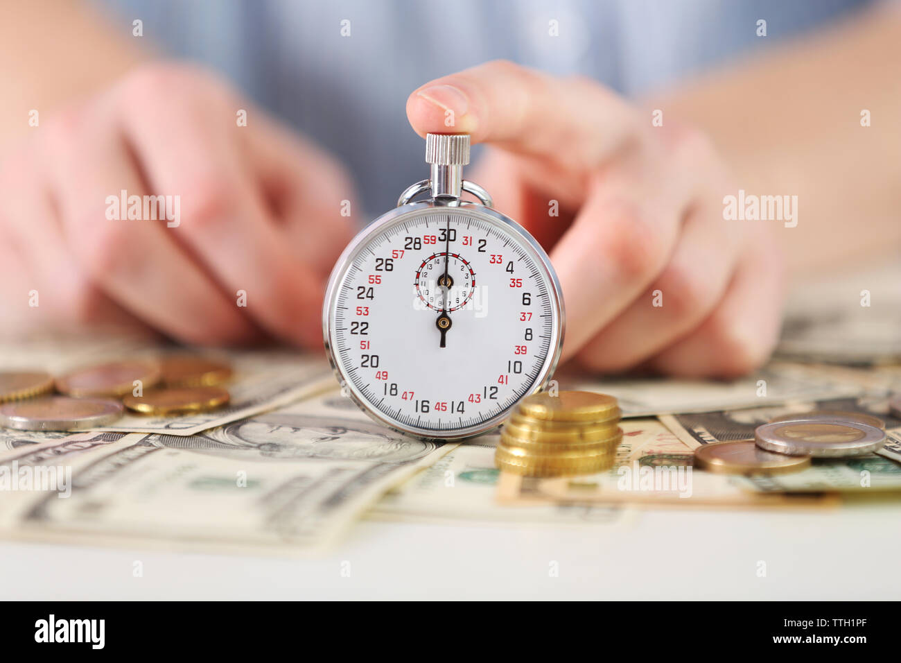 Time is money concept. Stopwatch on the table with money, close up ...