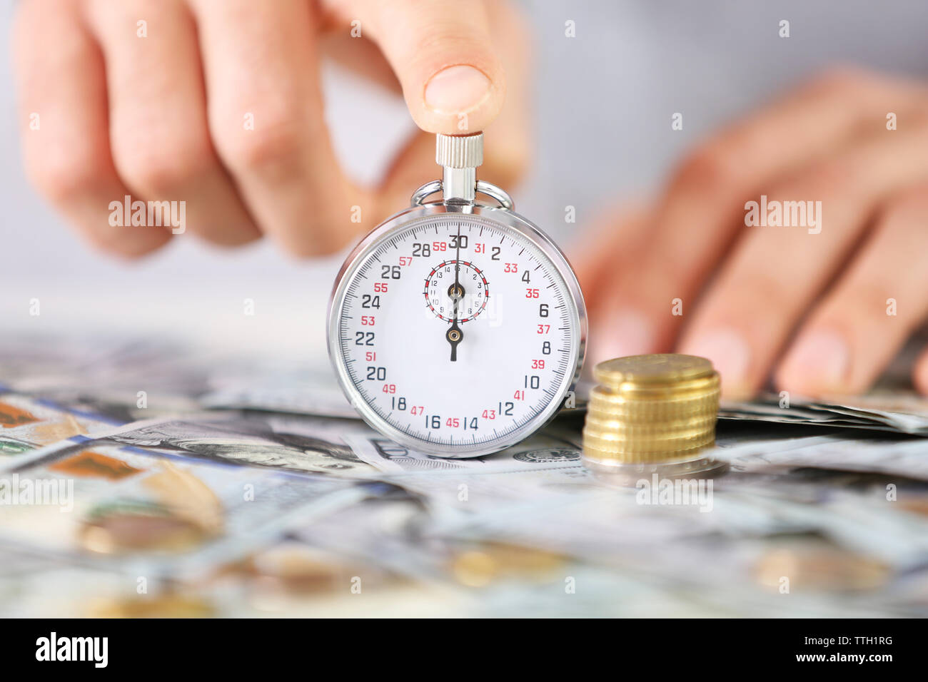 Time is money concept. Stopwatch on the table with money, close up ...