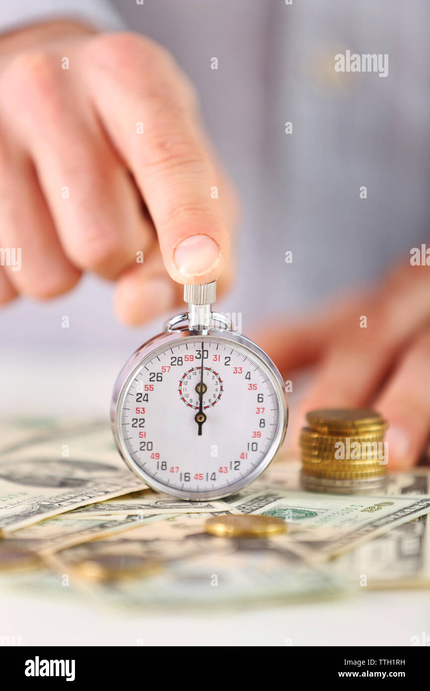 Time is money concept. Stopwatch on the table with money, close up ...