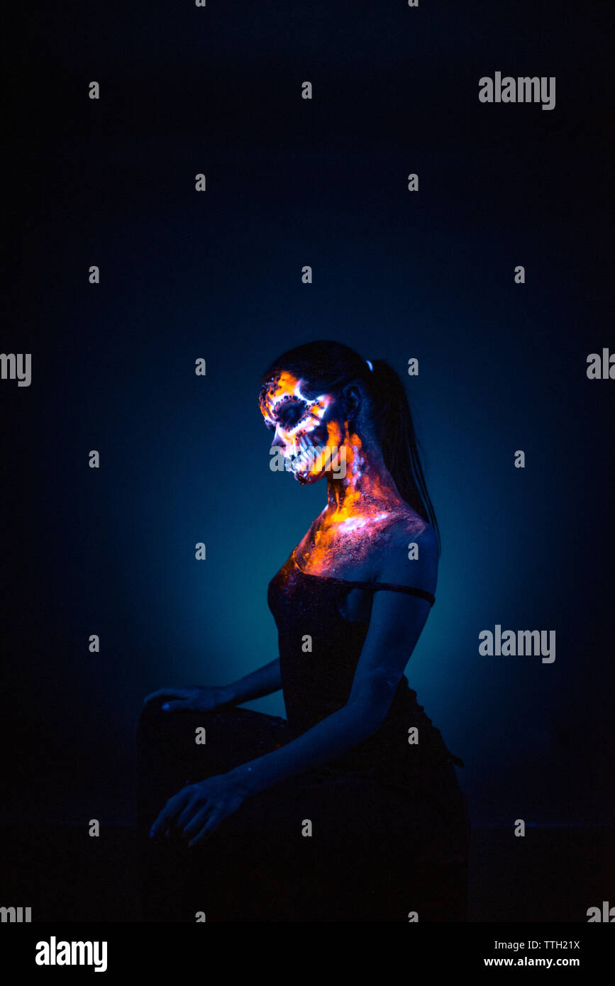 Girl's face painted UV skull Stock Photo - Alamy