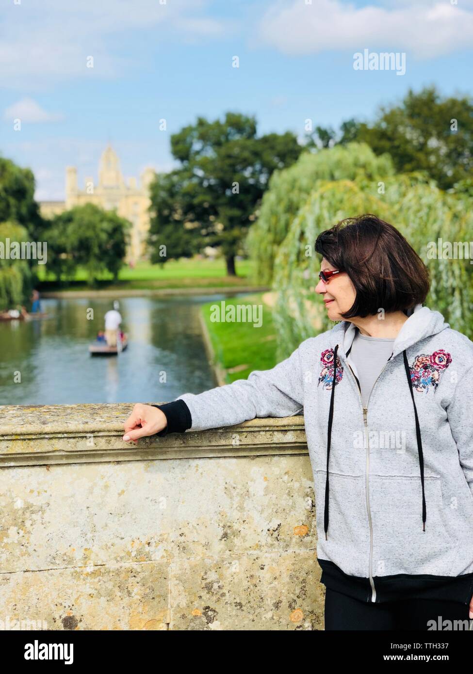 Woman looking from a bridge with a lake behind her Stock Photo - Alamy
