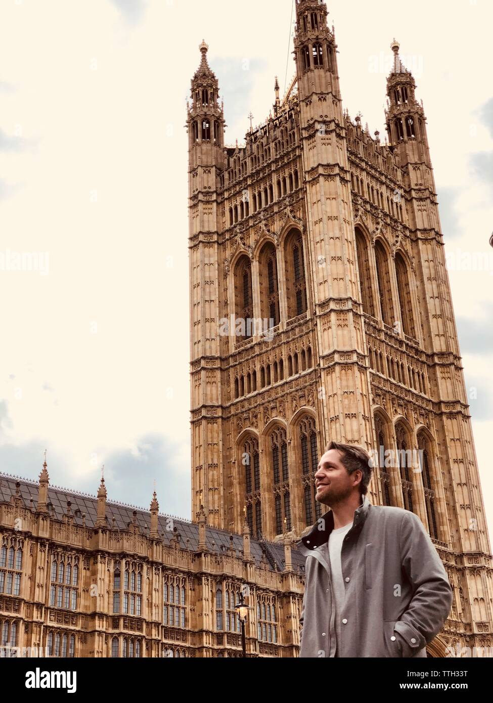 Man smiling standing in front of Parlament of London Stock Photo - Alamy