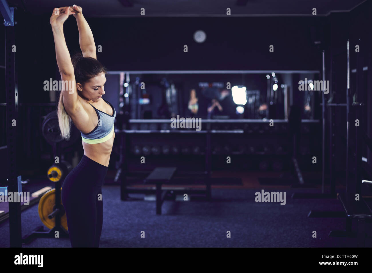 Side profile of young woman stretching at the fitness centre Stock ...