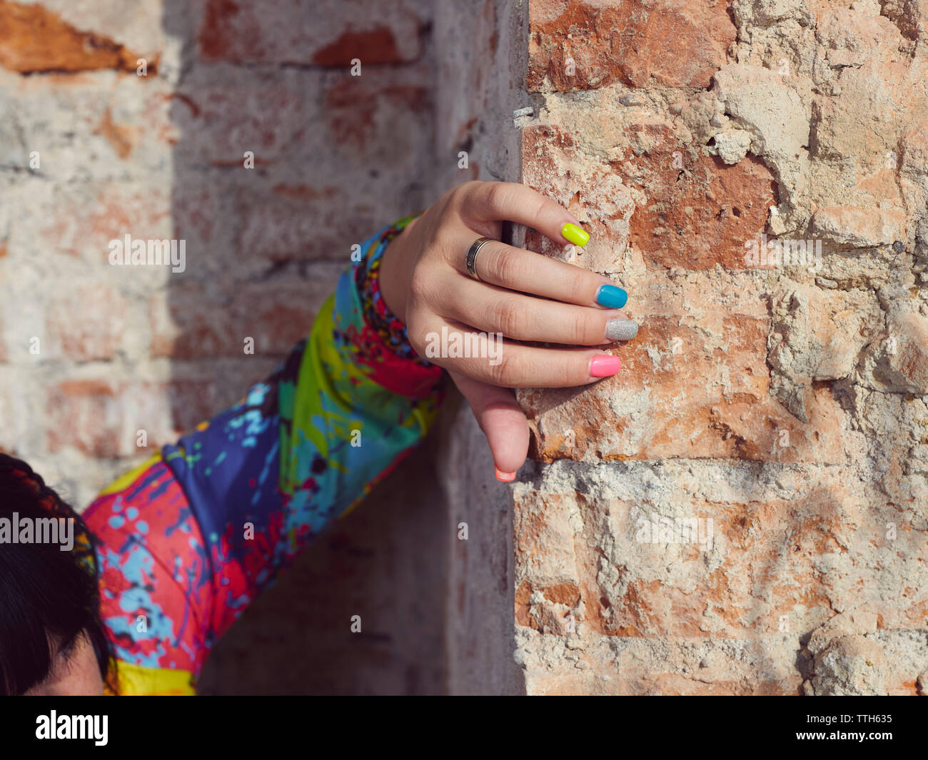 Close up of female hands with coloured nails on brick wall Stock Photo ...