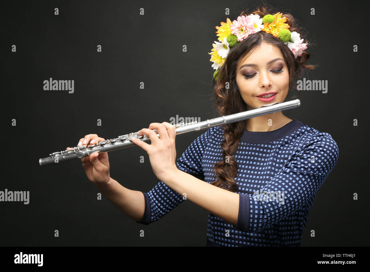 Beautiful young woman with flute on black background Stock Photo - Alamy