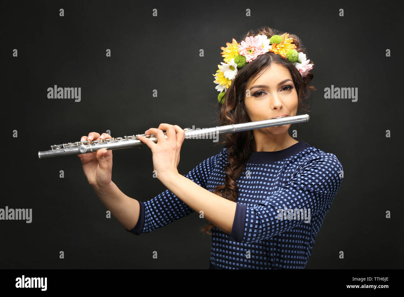 Beautiful young woman with flute on black background Stock Photo - Alamy