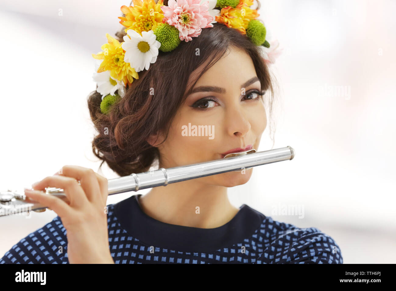 Beautiful young woman with flute on window background Stock Photo - Alamy