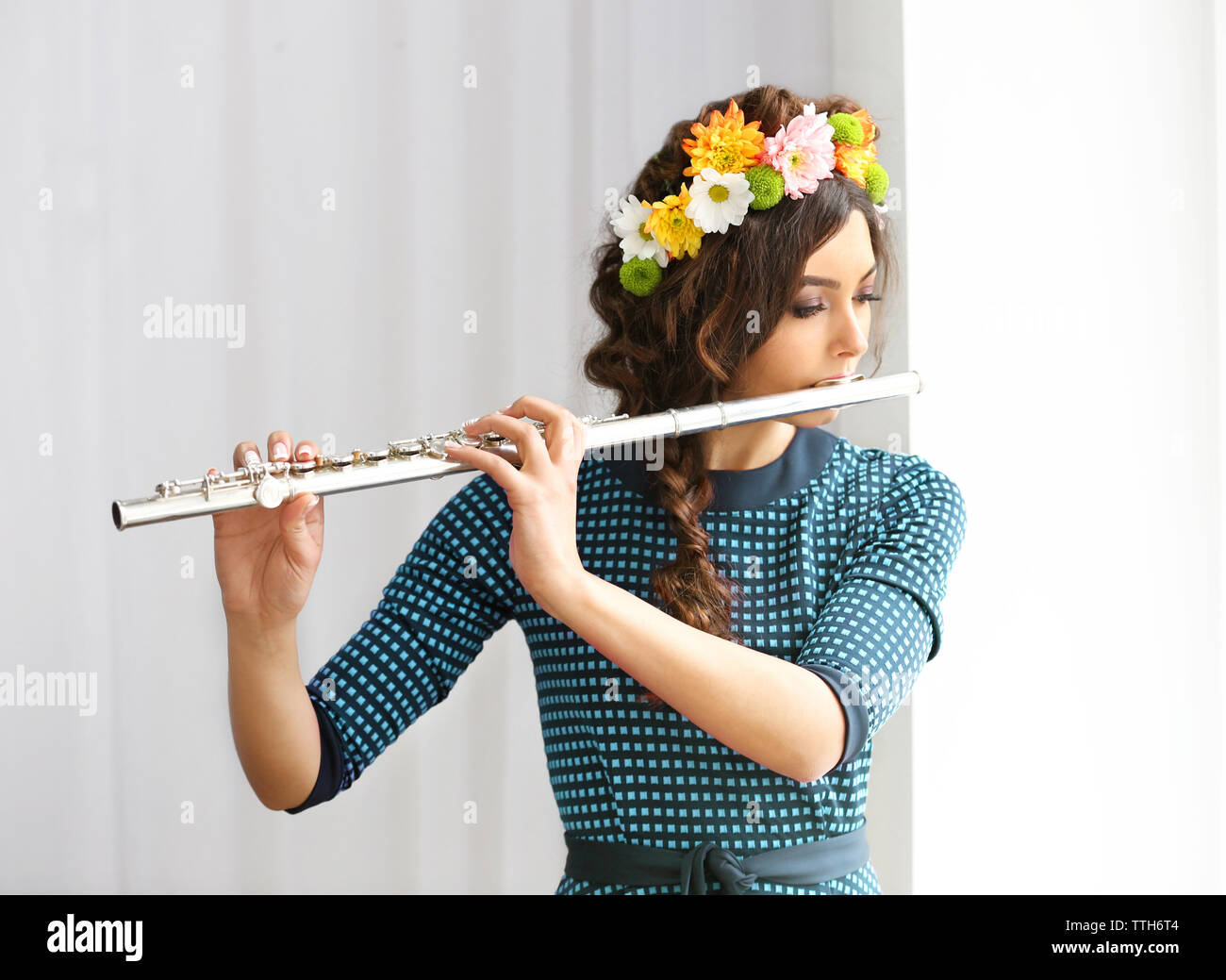 Beautiful young woman with flute on wall background Stock Photo - Alamy