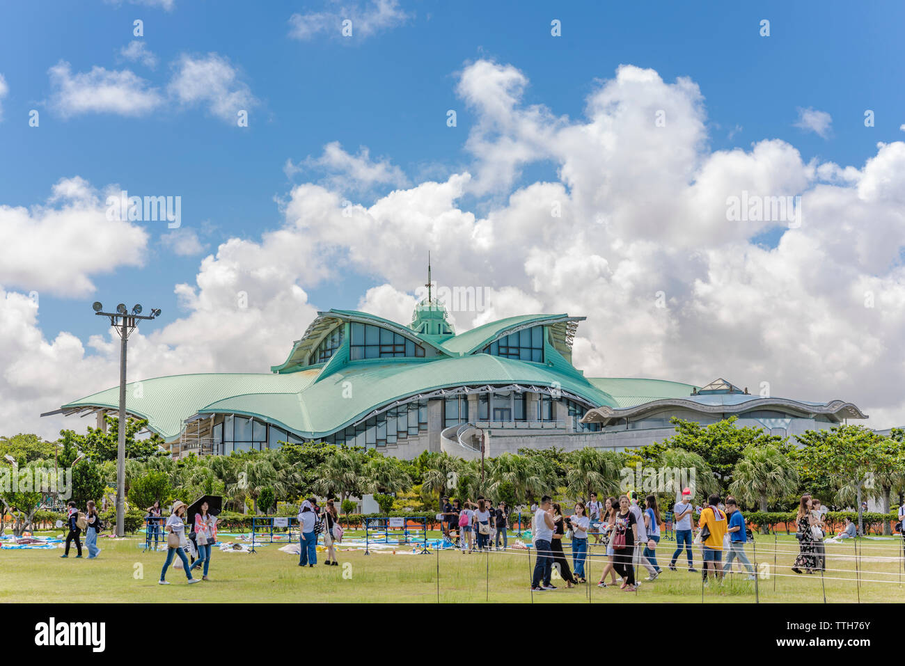 Building of Okinawa Convention Center decorated with palm trees near ...