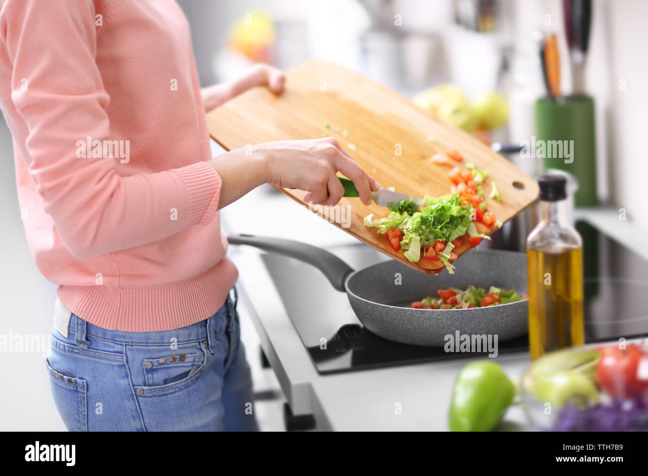 Woman frying vegetables in kitchen Stock Photo - Alamy