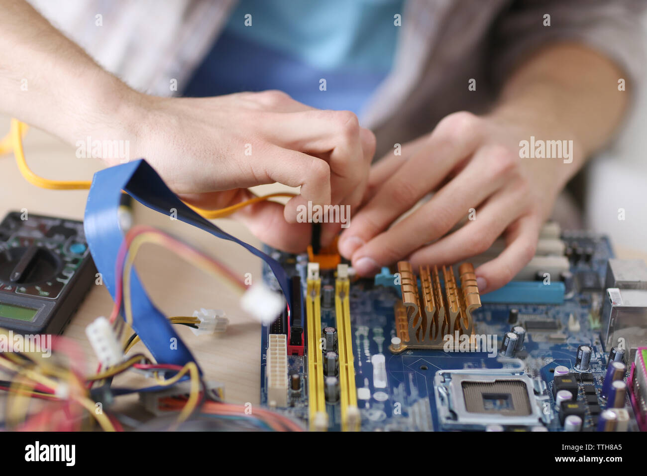 Young man repairing computer hardware in service center Stock Photo - Alamy