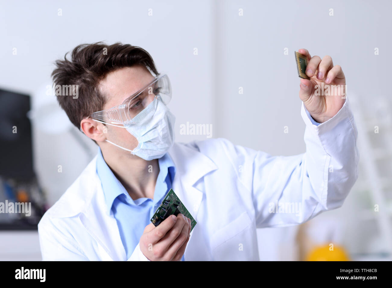 Young man in glasses and mask looking at the computer processor Stock ...