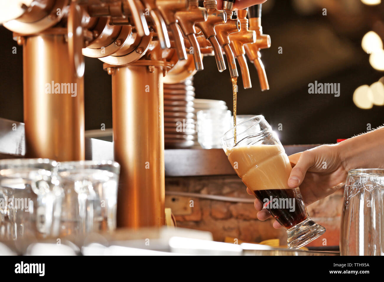Barman hand pouring a lager beer in a glass Stock Photo - Alamy