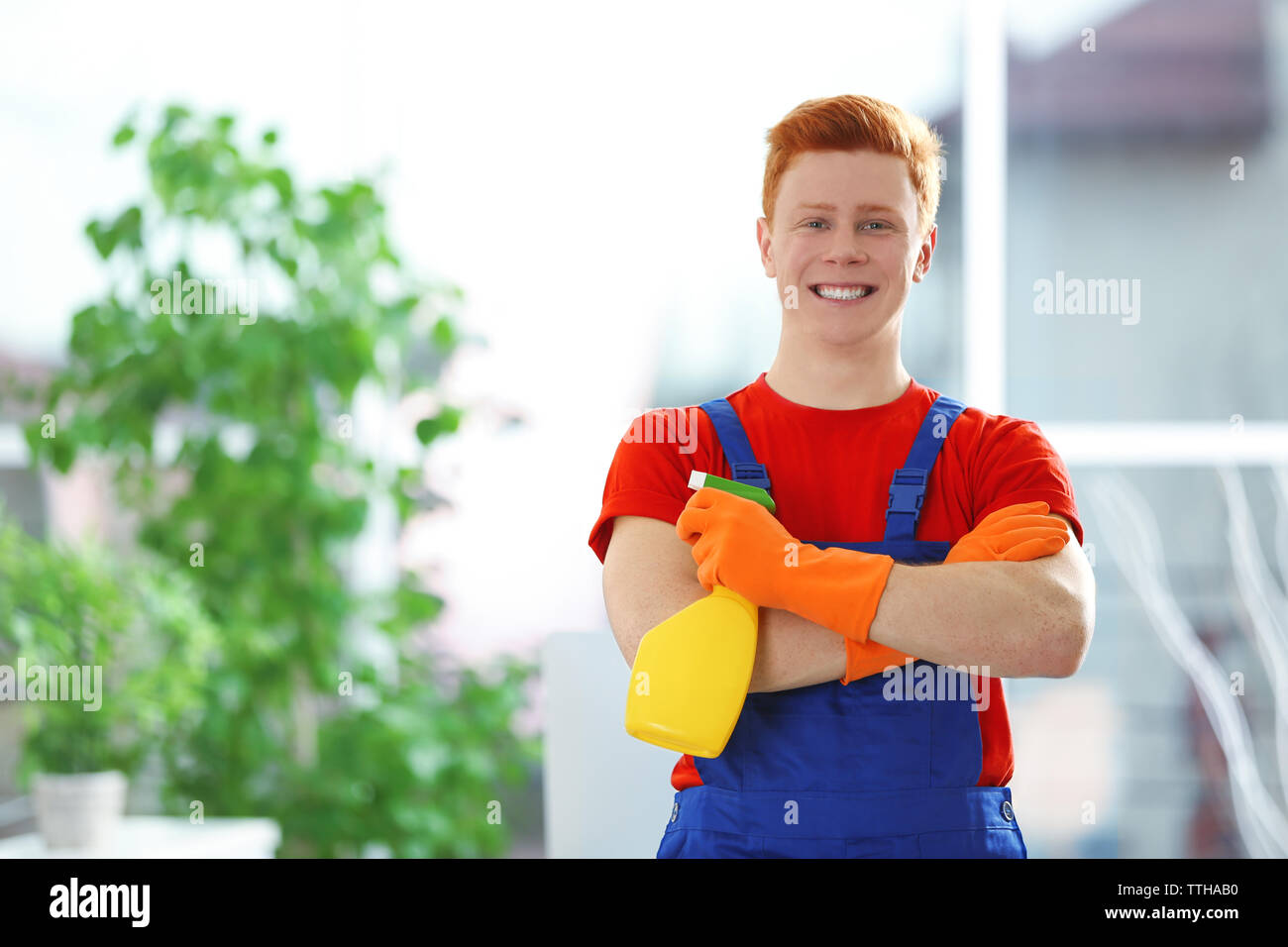 Young janitor holding liquid detergent in office Stock Photo - Alamy