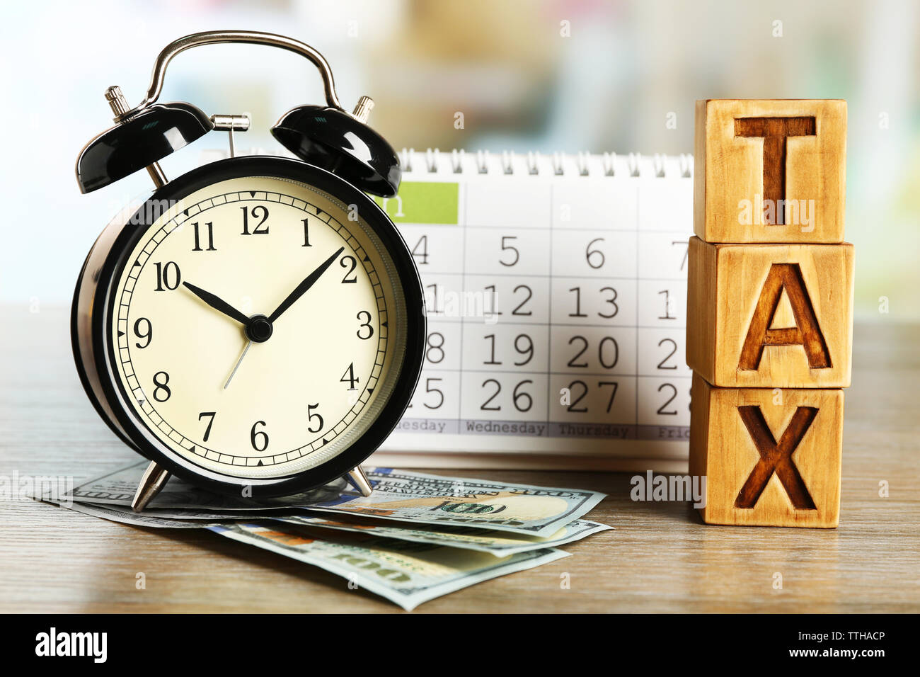 Tax time and alarm clock with dollars and calendar Stock Photo - Alamy