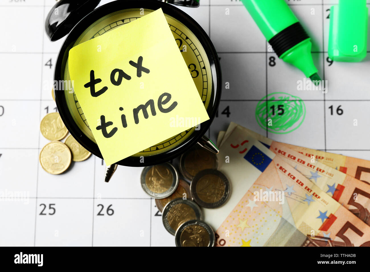 Tax time on alarm clock with euro, marker and calendar Stock Photo - Alamy