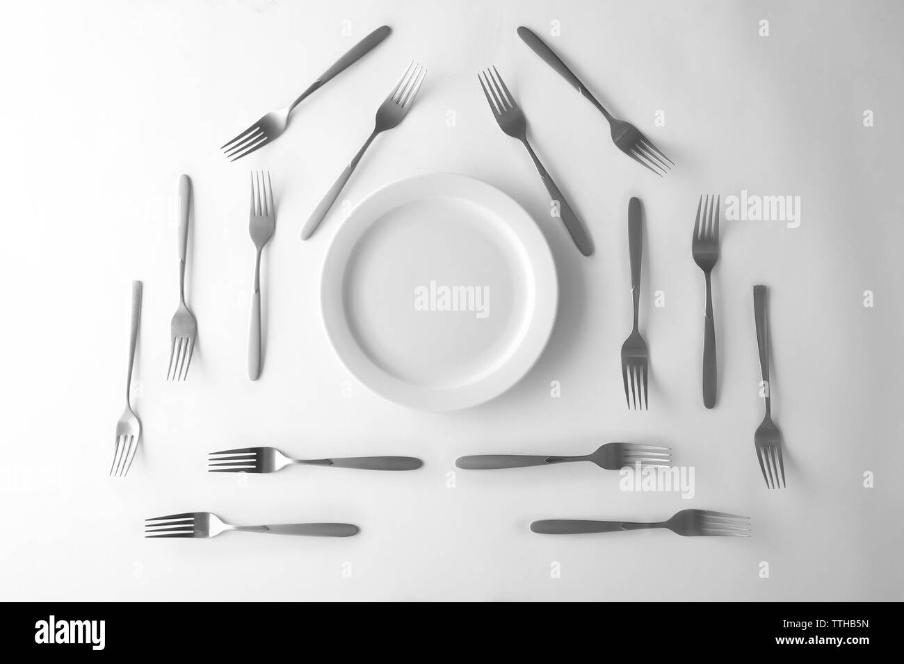 Plate and silver forks, top view Stock Photo - Alamy