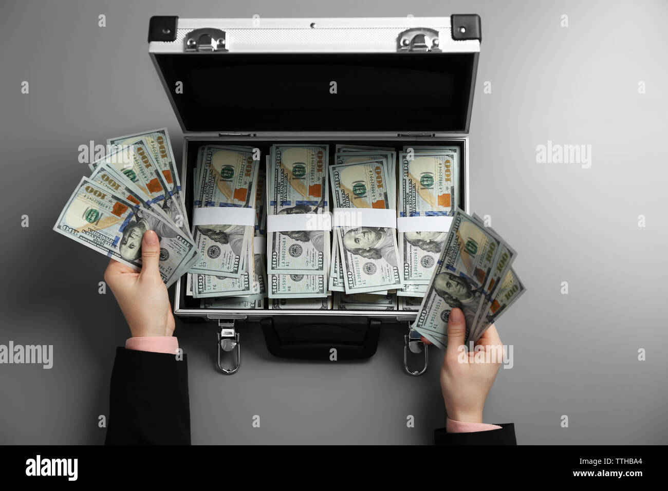 Businesswoman with case full of money Stock Photo - Alamy