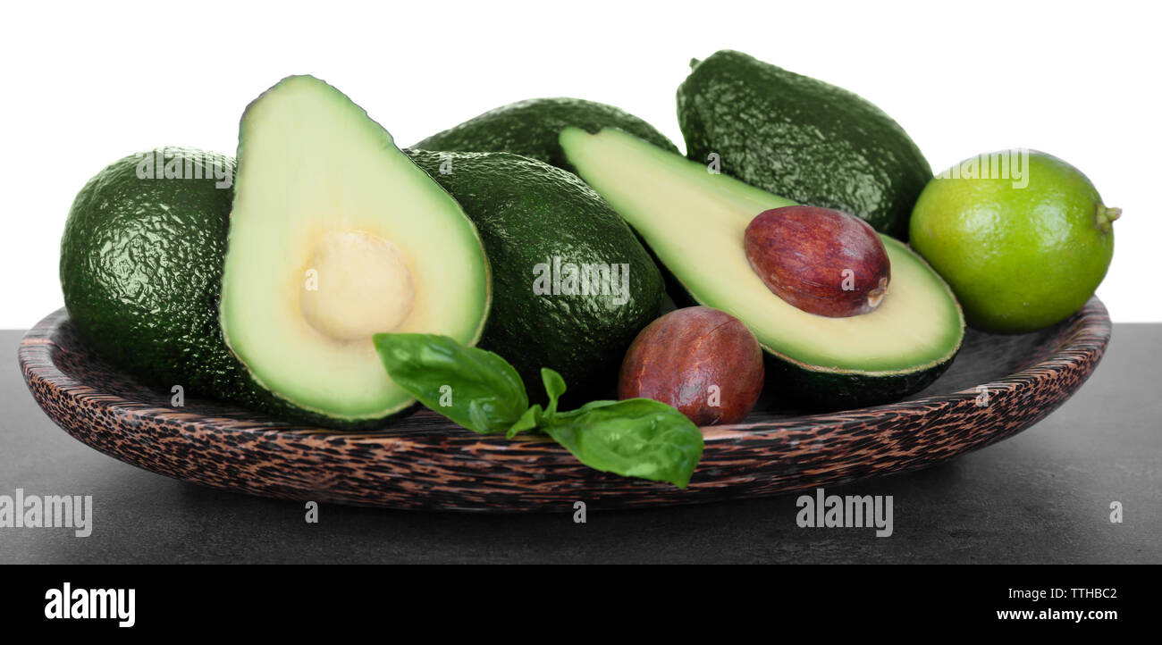 Wooden plate full of avocados on a white background Stock Photo - Alamy