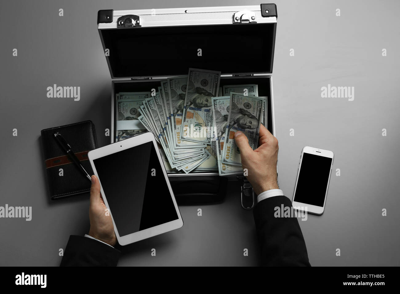 Businessman with tablet counting money Stock Photo - Alamy