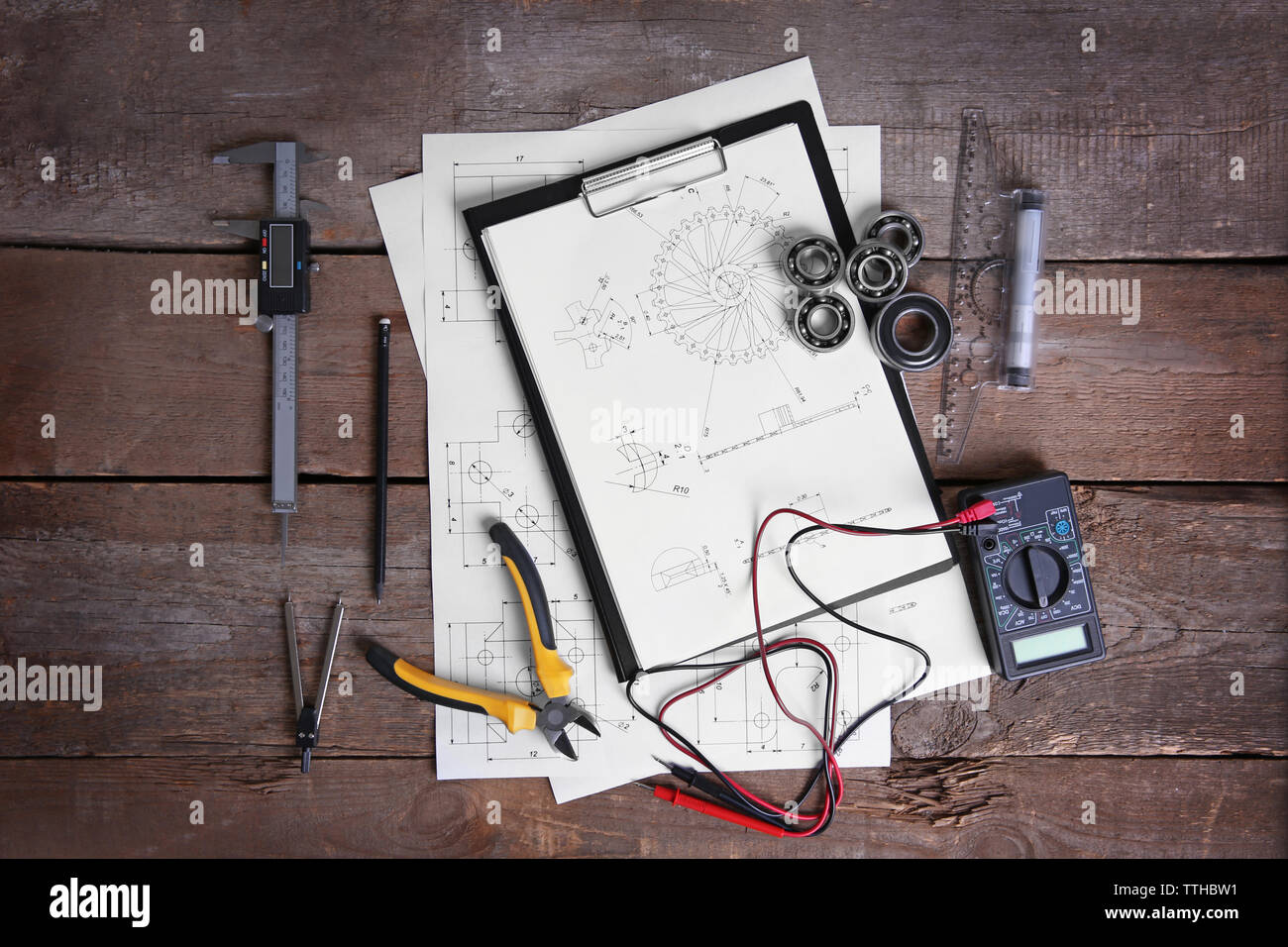 Digital multimeter and blueprints on a wooden background Stock Photo ...