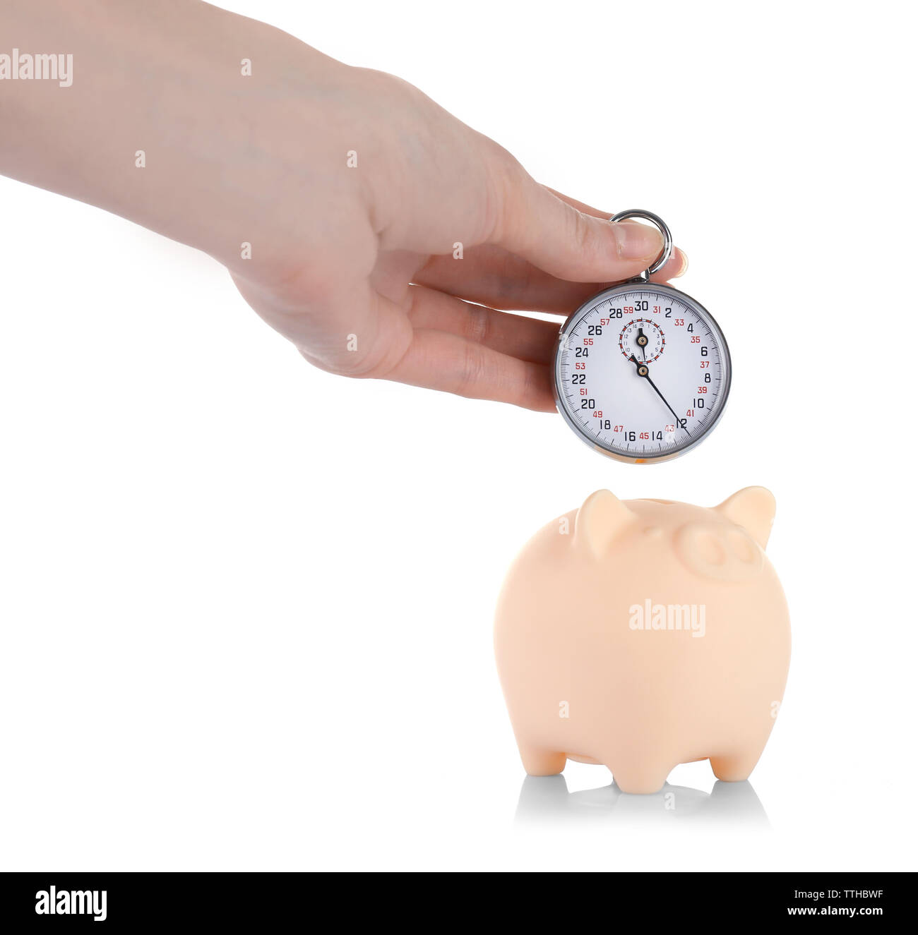 Beige piggy bank and a hand holding timer above it isolated on white ...