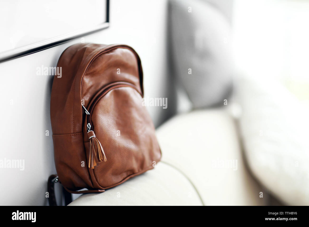Brown leather backpack on the couch Stock Photo - Alamy