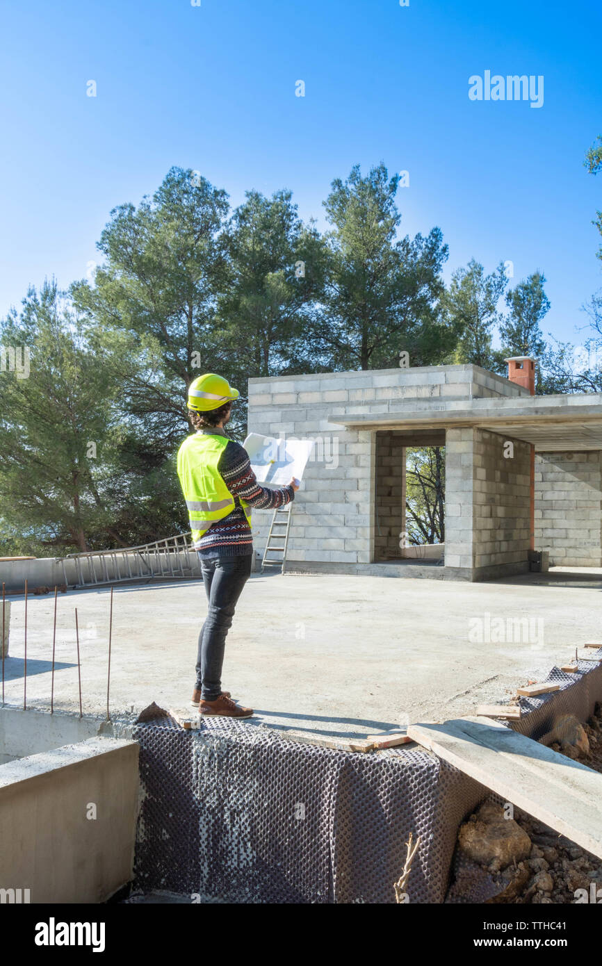 Architect checking the plans of a house under construction Stock Photo ...