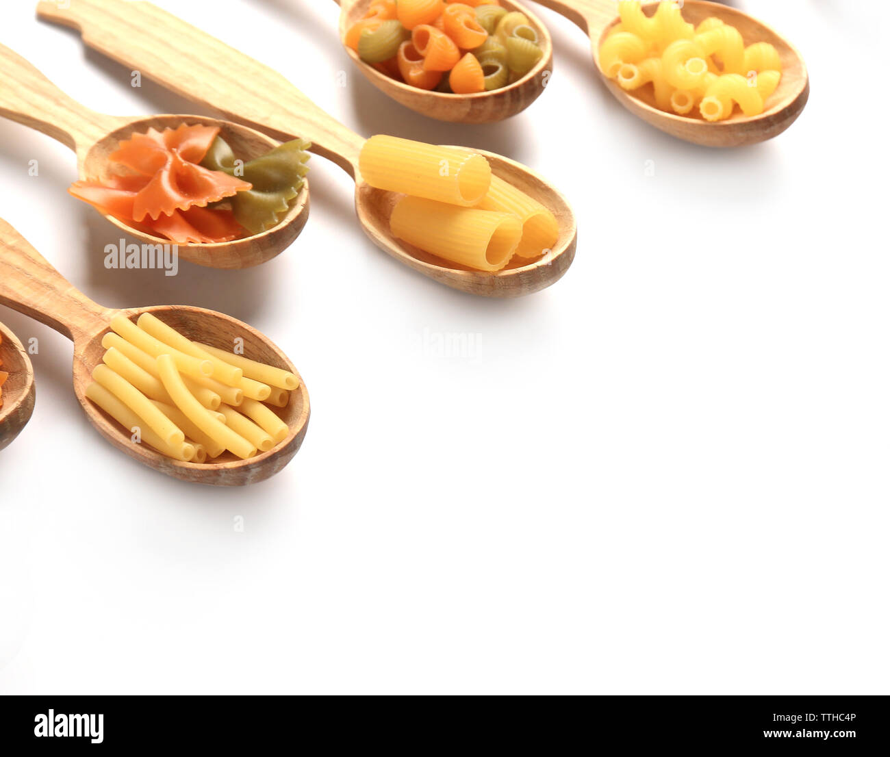Different types of dry pasta in wooden spoons on white background Stock ...
