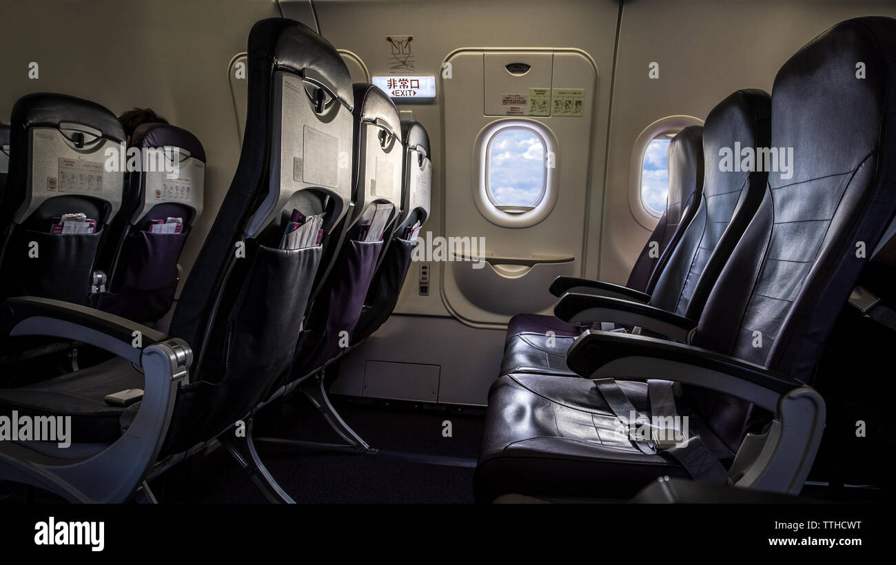 Airplane seat and windows inside an aircraft. View on blue sky and ...