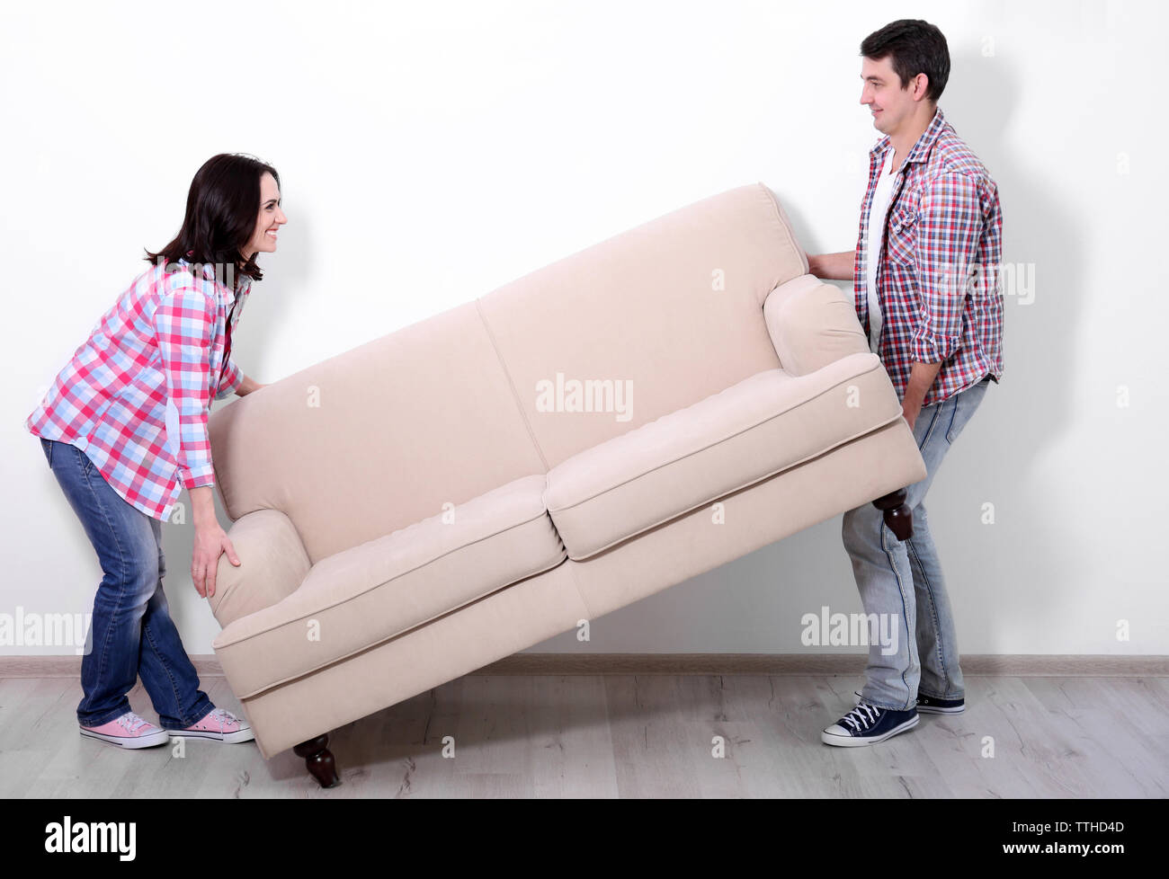 Young couple carrying sofa in their new house Stock Photo - Alamy