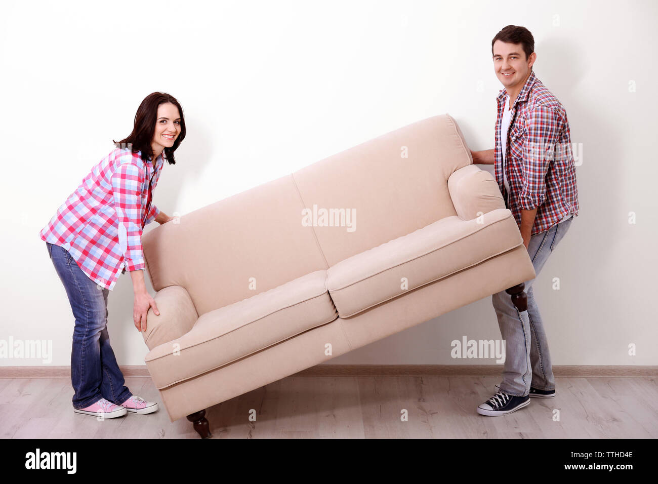 Young couple carrying sofa in their new house Stock Photo - Alamy