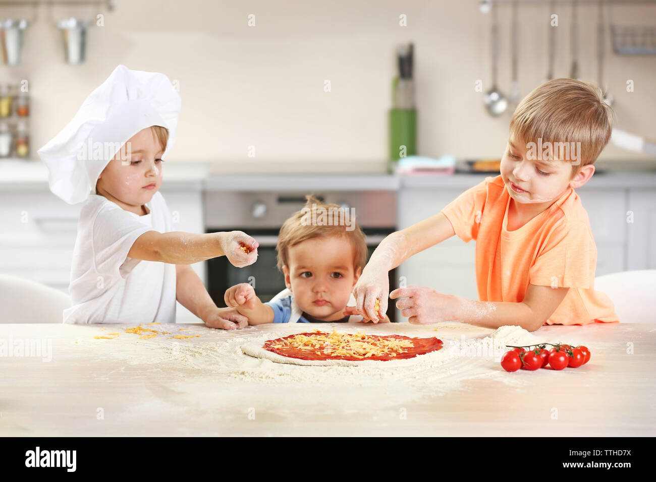 Three little boys making a pizza , close up Stock Photo - Alamy