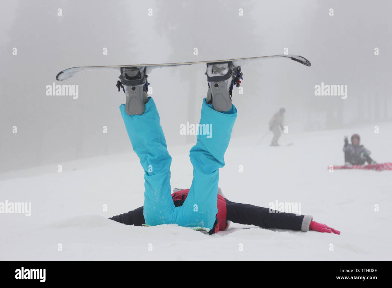 Girl snowboarder falling over white snow background Stock Photo - Alamy