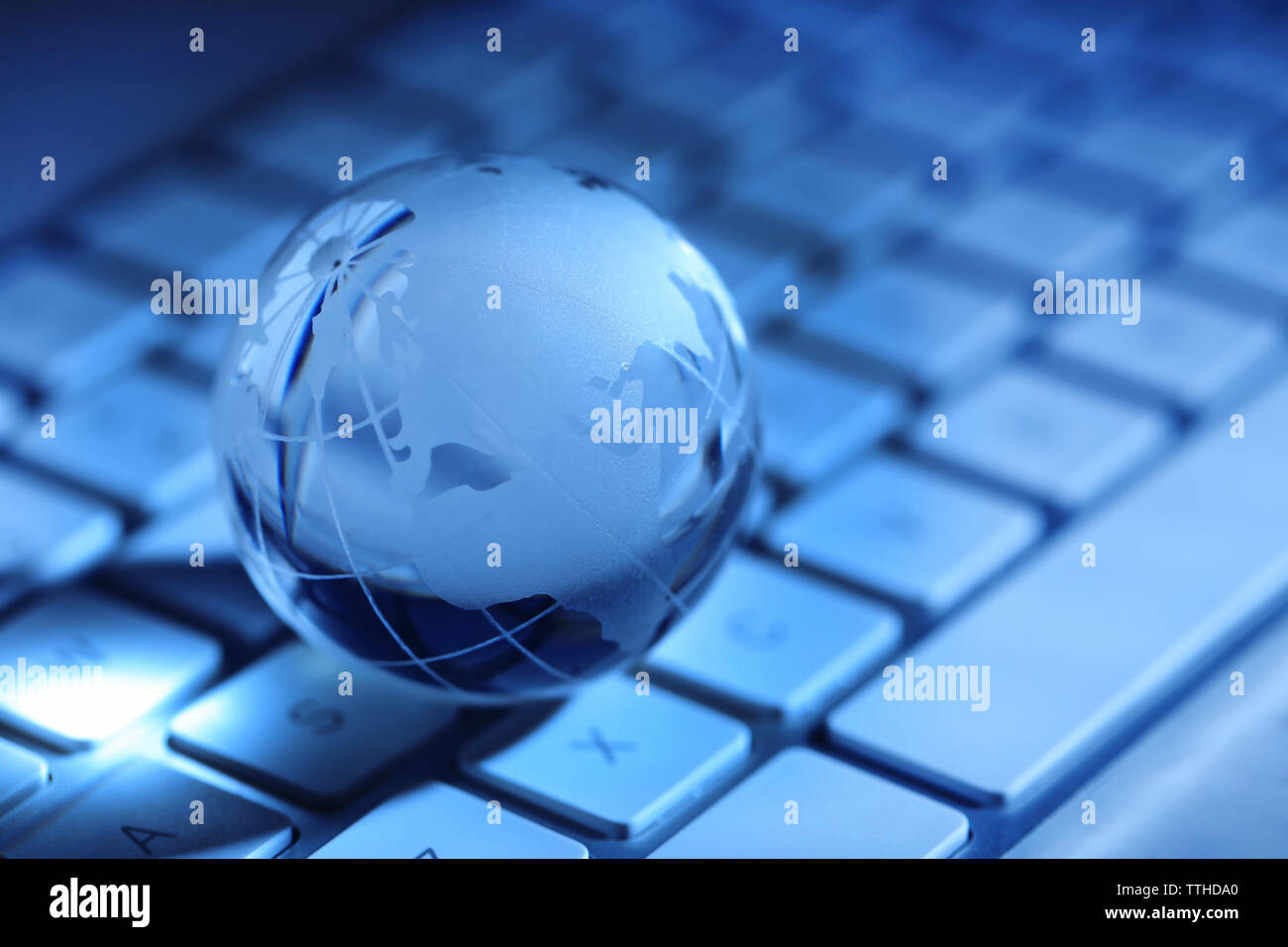 Crystal globe on laptop keyboard, close up Stock Photo - Alamy