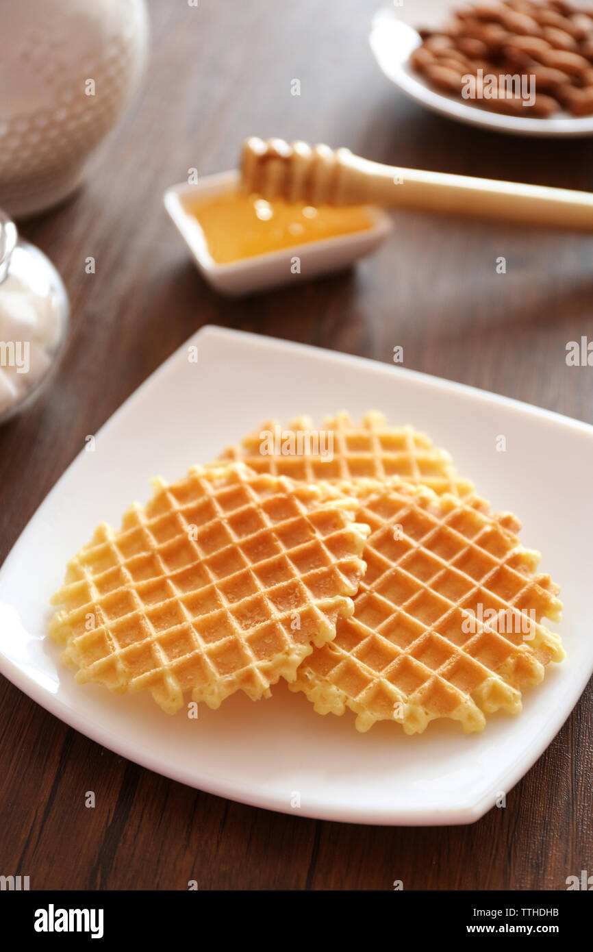 Tasty waffles with honey on plate Stock Photo - Alamy