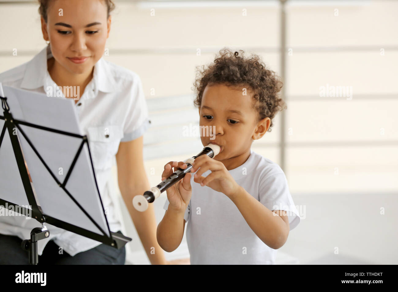 Young girl teaching little boy to playing on recorder Stock Photo - Alamy