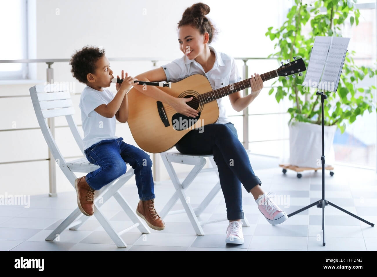Young girl and little boy playing on music instruments Stock Photo - Alamy