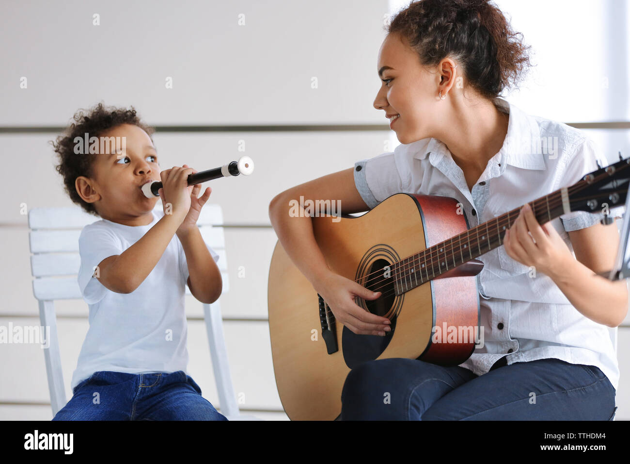 Young girl and little boy playing on music instruments Stock Photo - Alamy