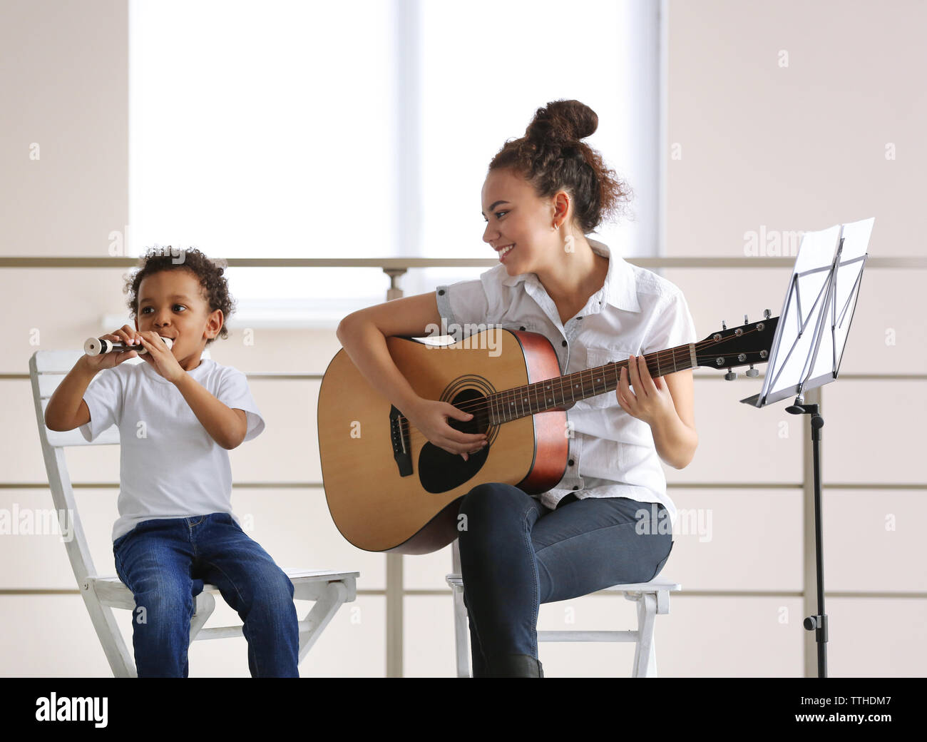 Young girl and little boy playing on music instruments Stock Photo - Alamy