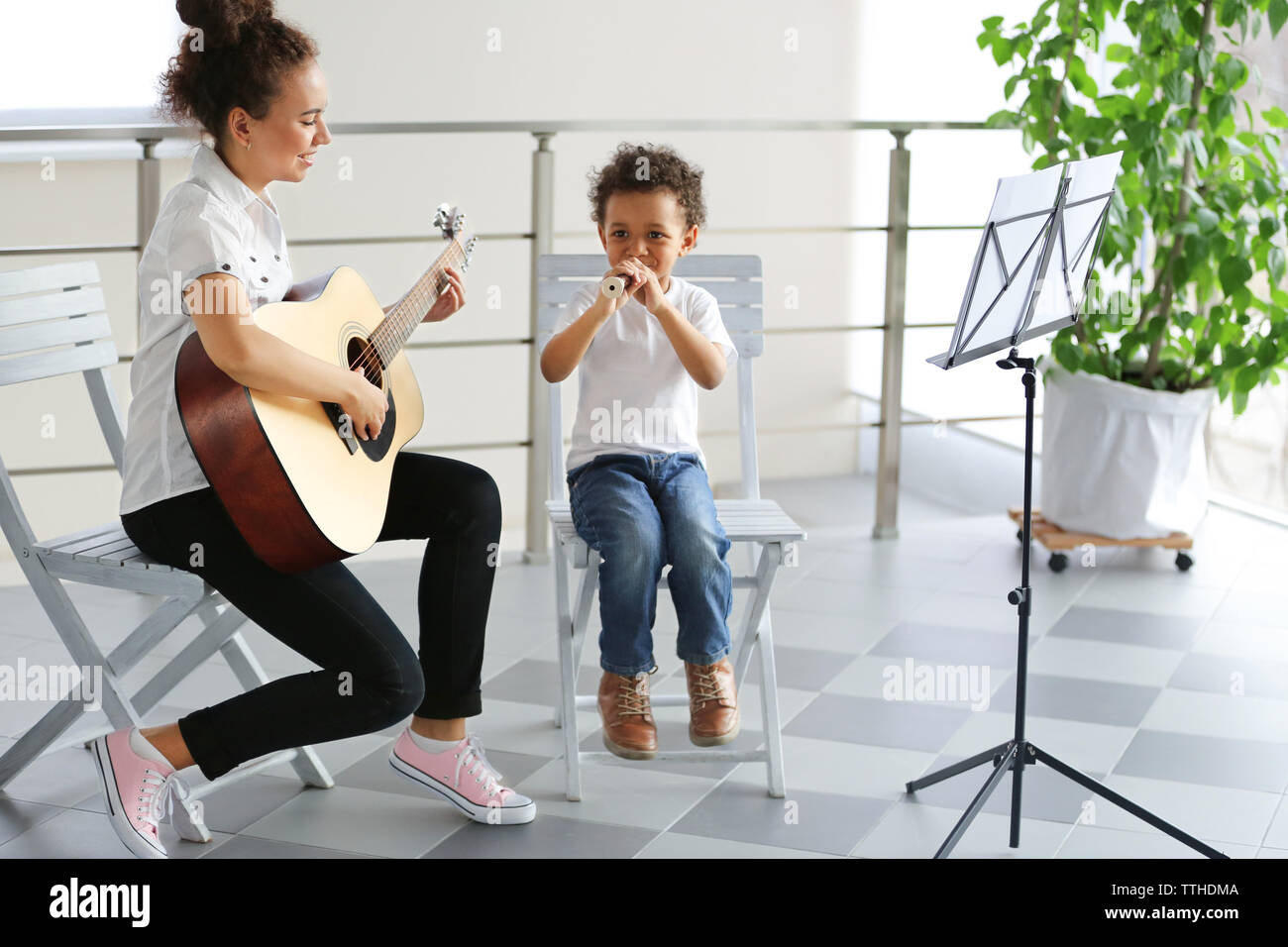 Young girl and little boy playing on music instruments Stock Photo - Alamy