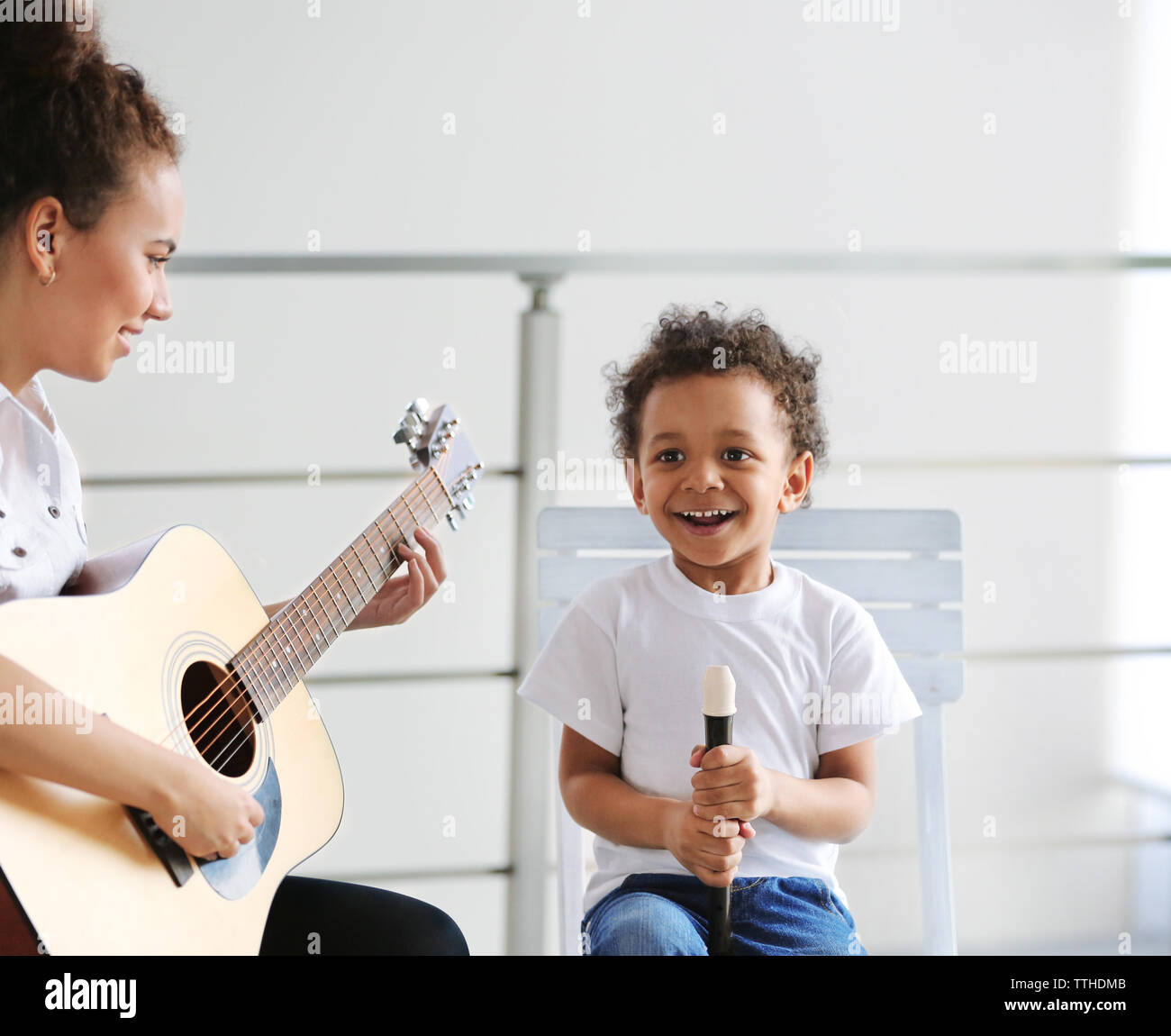 Young girl and little boy playing on music instruments Stock Photo - Alamy