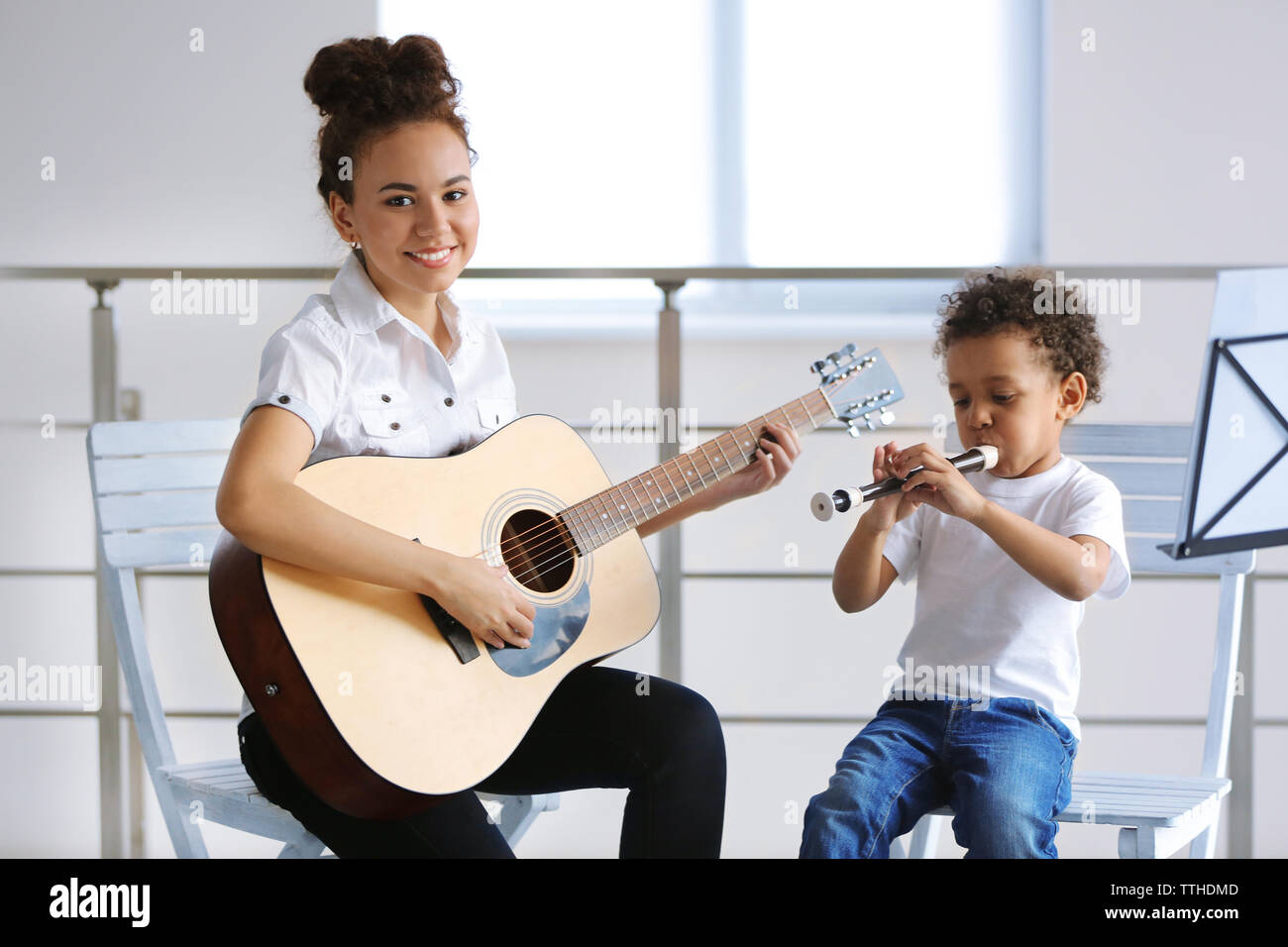 Young girl and little boy playing on music instruments Stock Photo - Alamy