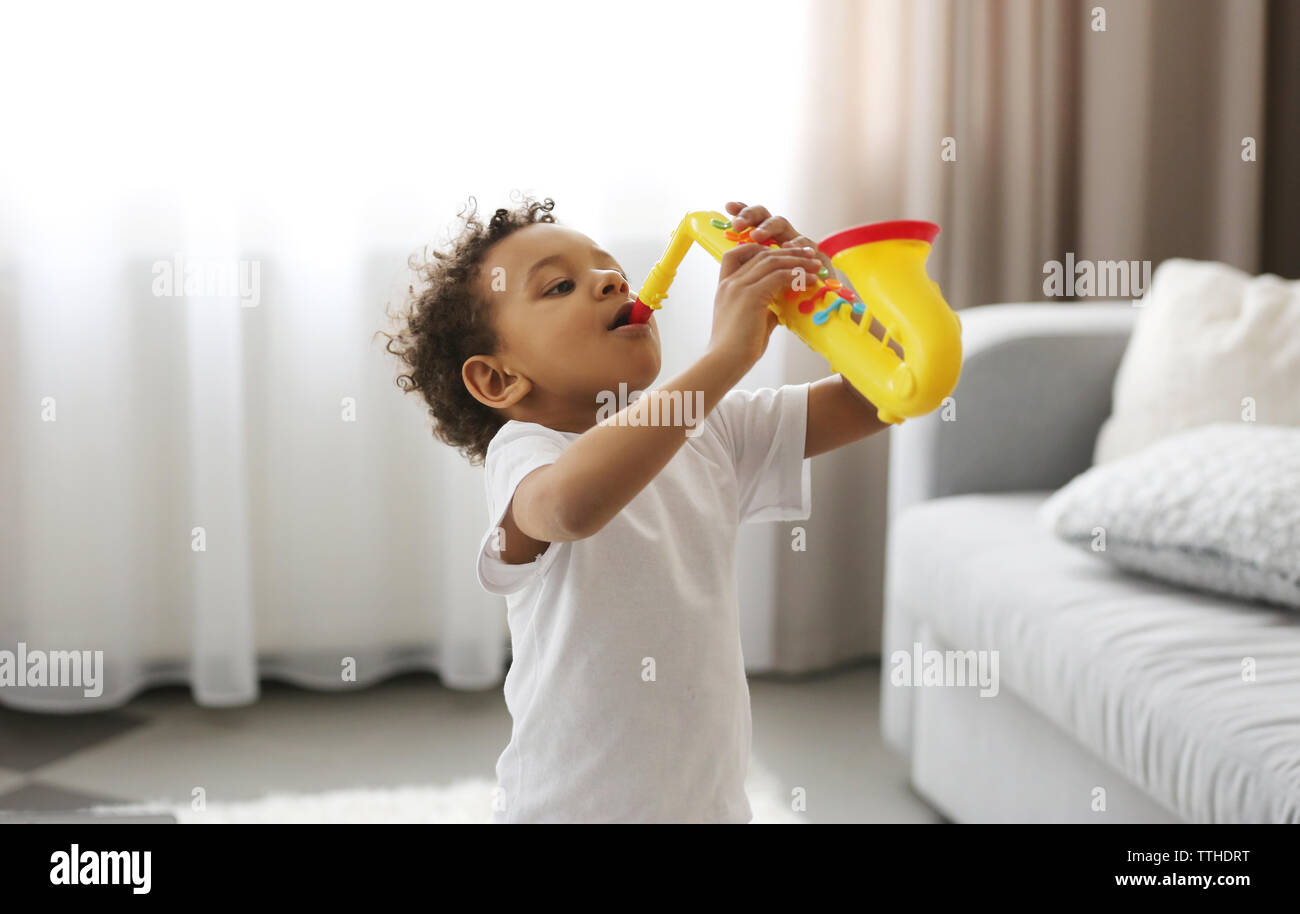 Little boy playing on toy saxophone Stock Photo - Alamy