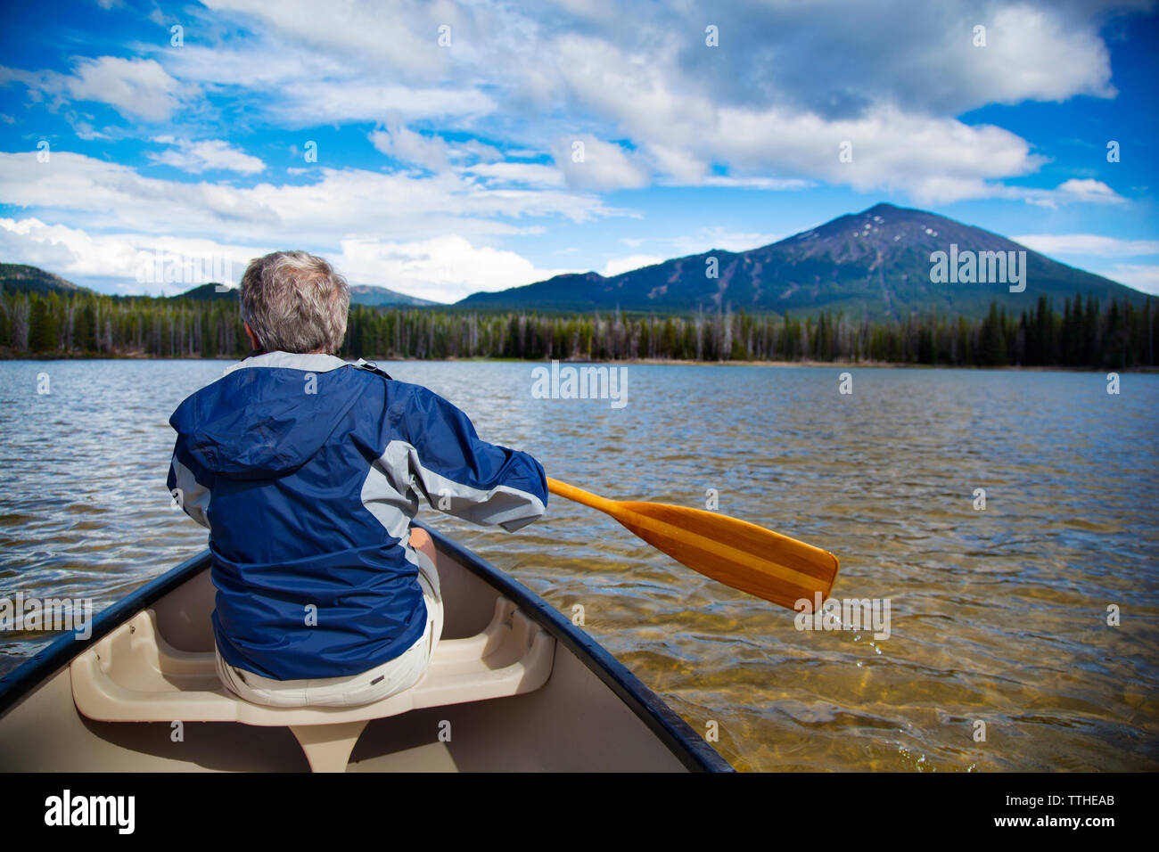 Rear view of man boating in lake towards mountain Stock Photo - Alamy