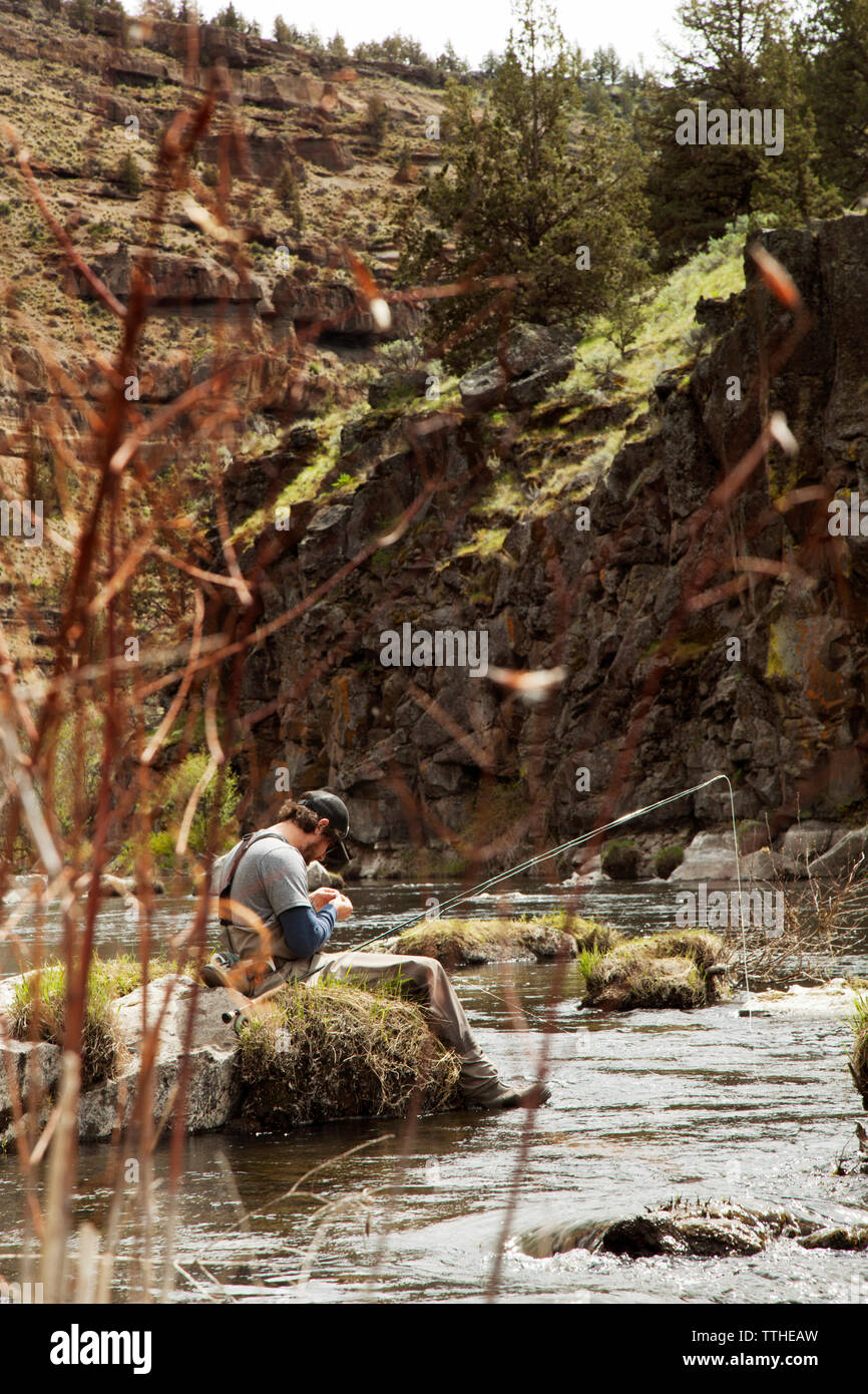 Side view of man fishing in lake against mountain Stock Photo - Alamy