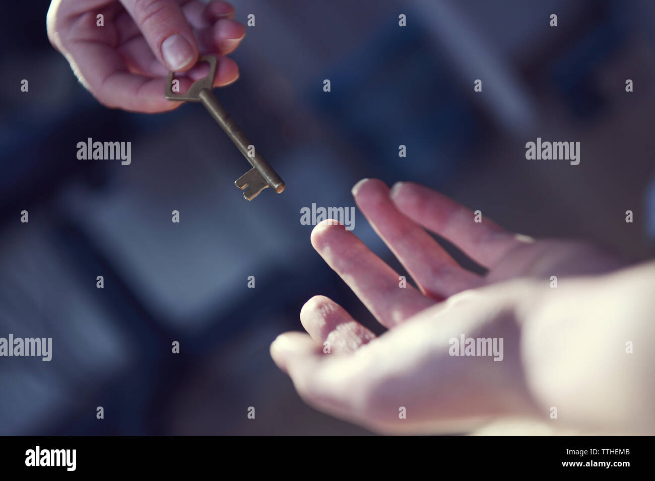 Female hand giving old key to other hand on blurred background Stock ...
